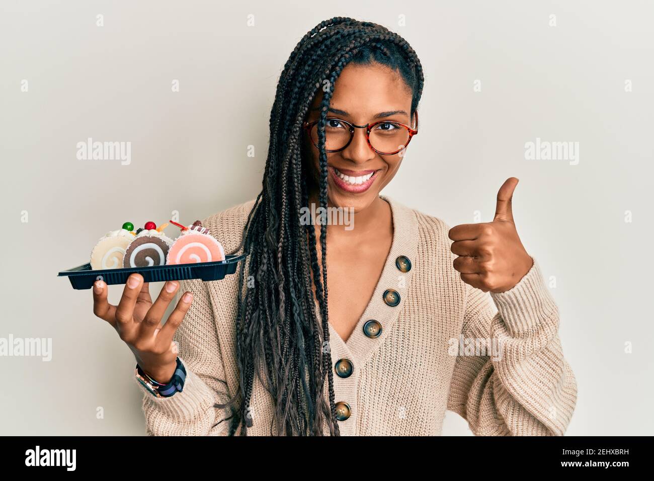 African american woman holding cake sweets smiling happy and positive ...