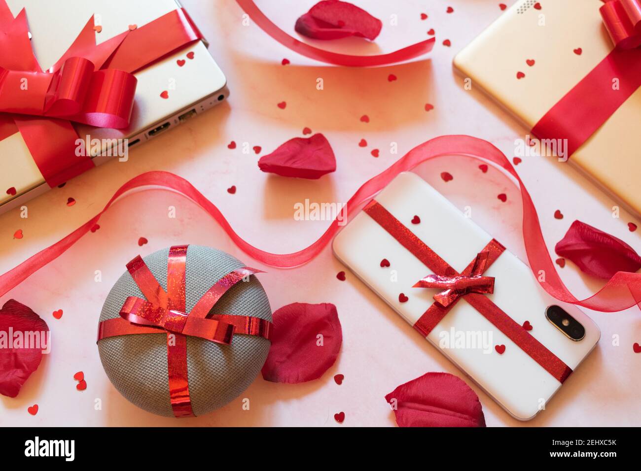 Tech gifts wrapped with red gift bows, tablet, cell phone, laptop ...