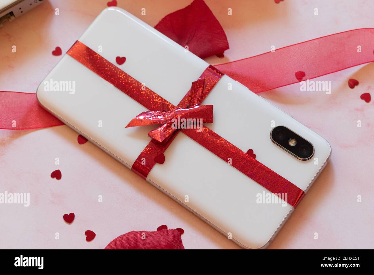 mobile phone gift wrapped with bow on white background Stock Photo - Alamy