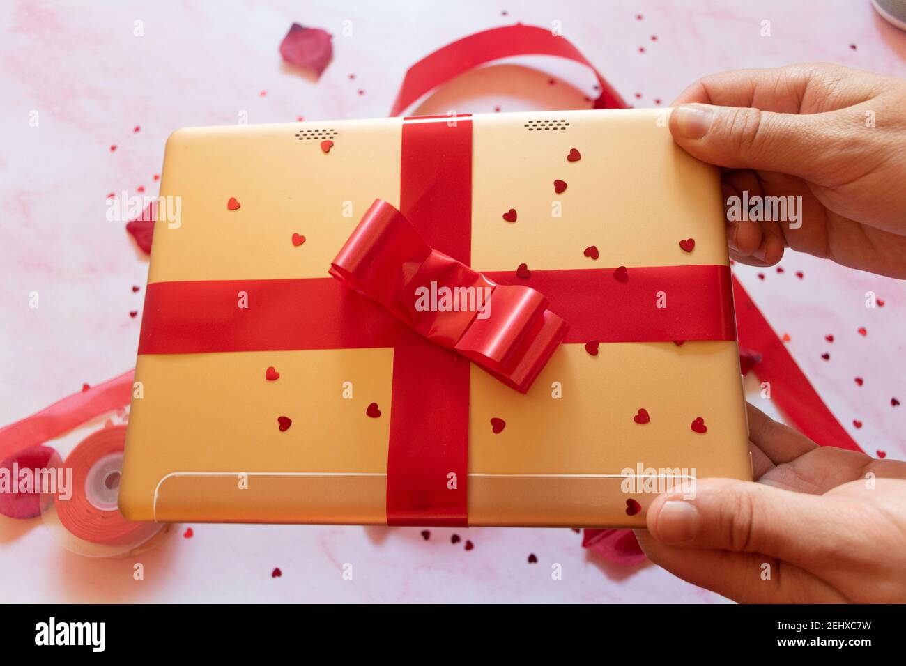 gift wrapped tablet with red bow and background ornaments Stock Photo ...