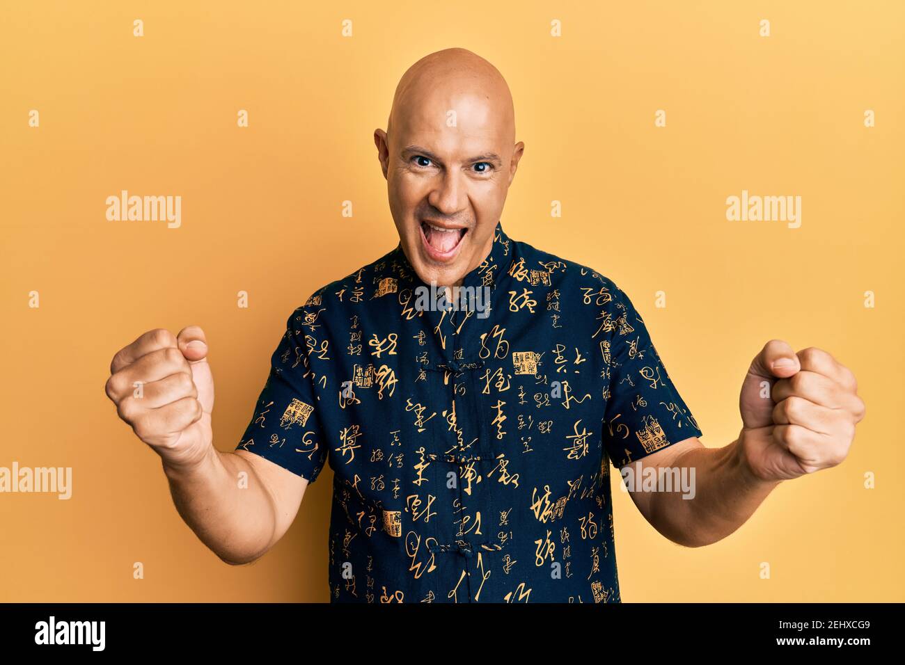 Middle age bald man wearing casual clothes screaming proud, celebrating ...
