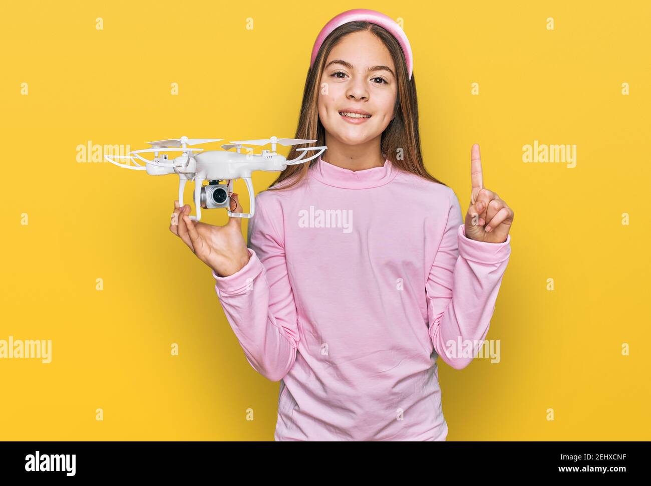 Beautiful brunette little girl using drone surprised with an idea or ...