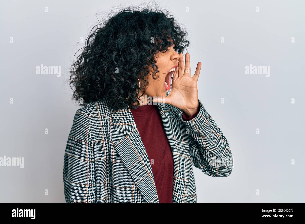 Young hispanic woman wearing business clothes shouting and screaming ...