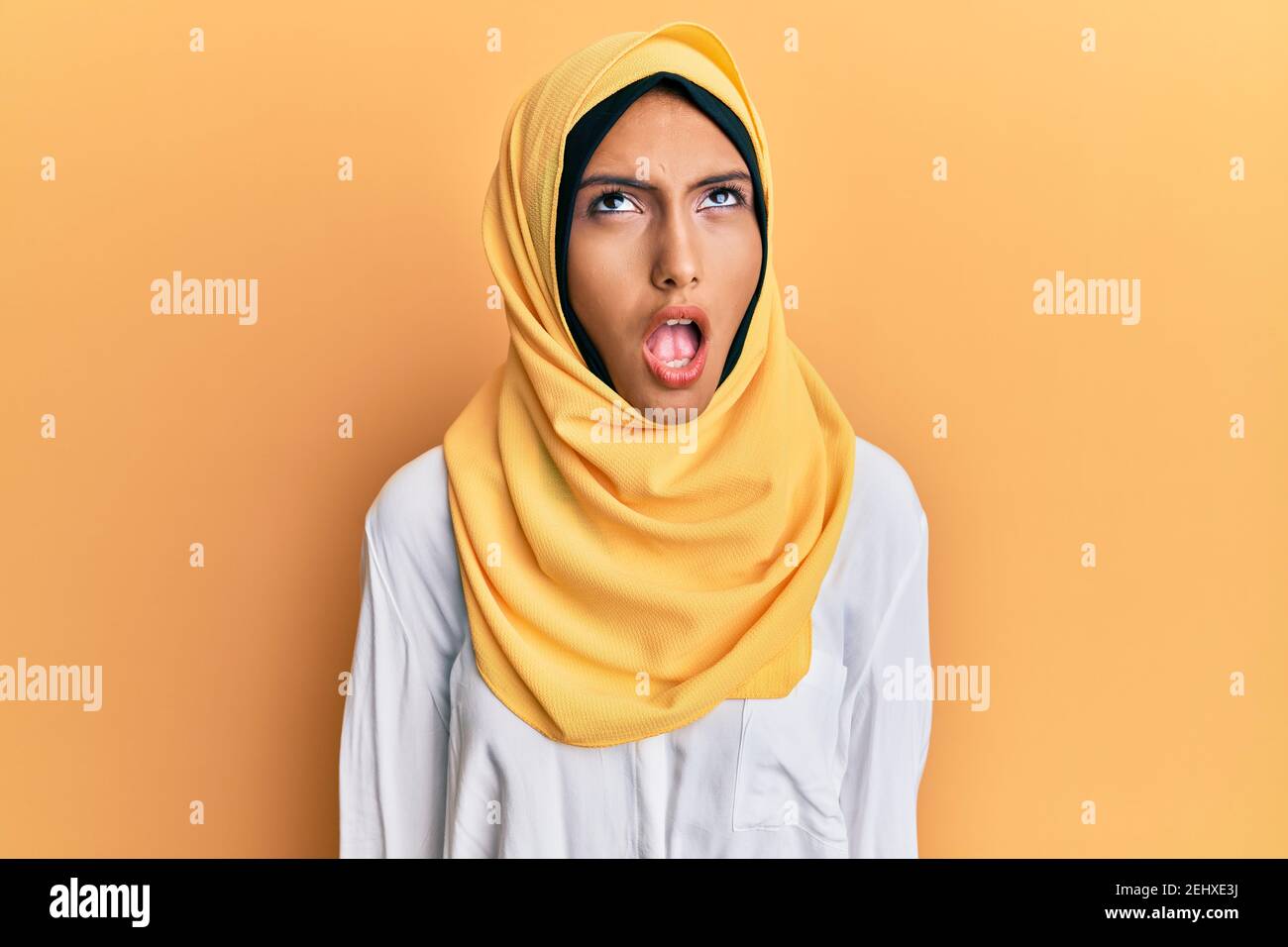 Young brunette arab woman wearing traditional islamic hijab scarf angry ...