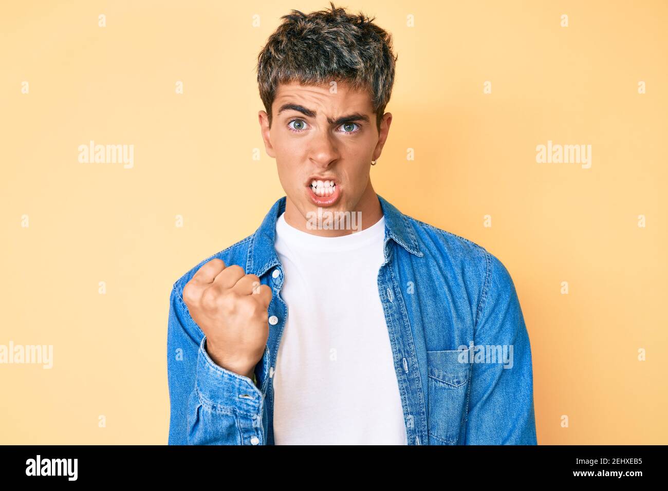 Young handsome man wearing casual clothes angry and mad raising fist ...