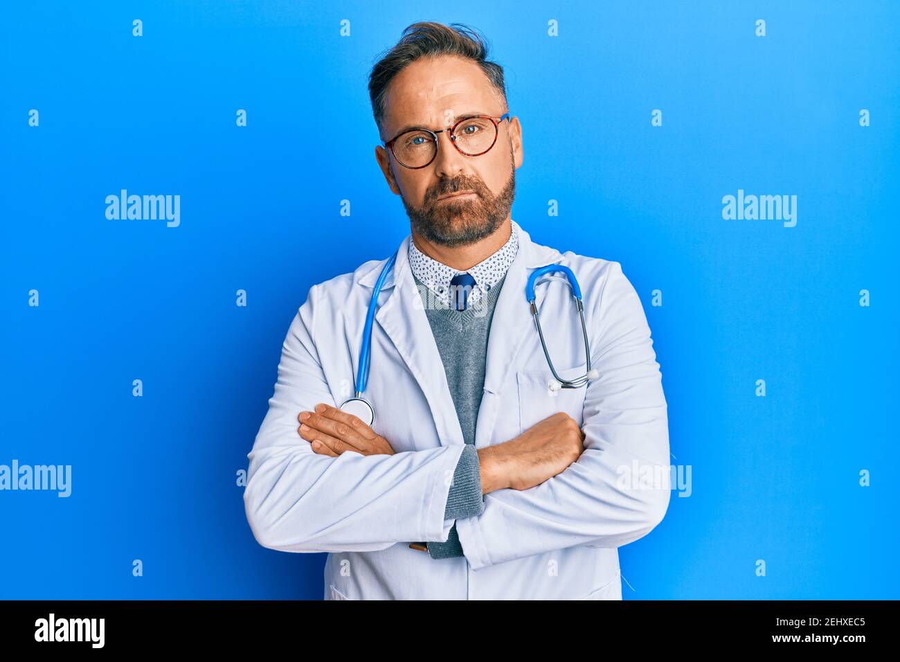 Handsome middle age man wearing doctor uniform and stethoscope skeptic ...