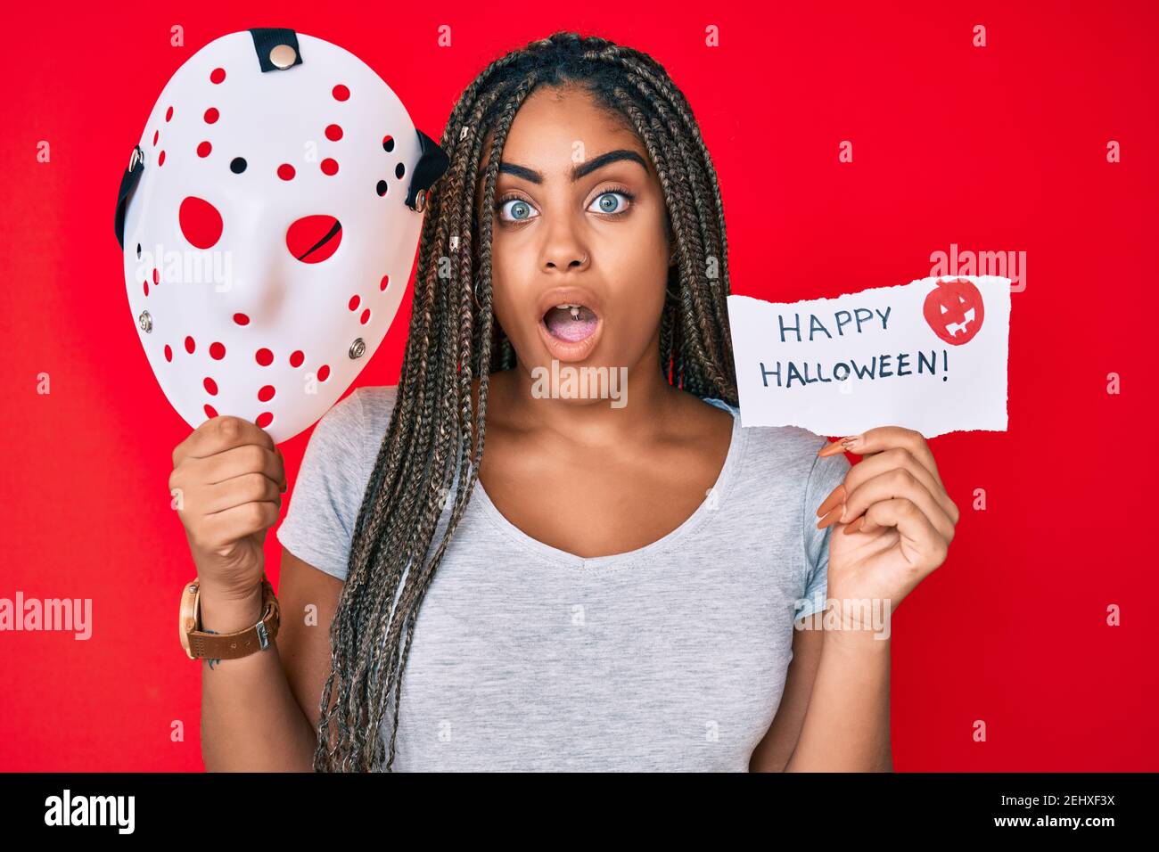 Young african american woman with braids holding halloween banner and ...