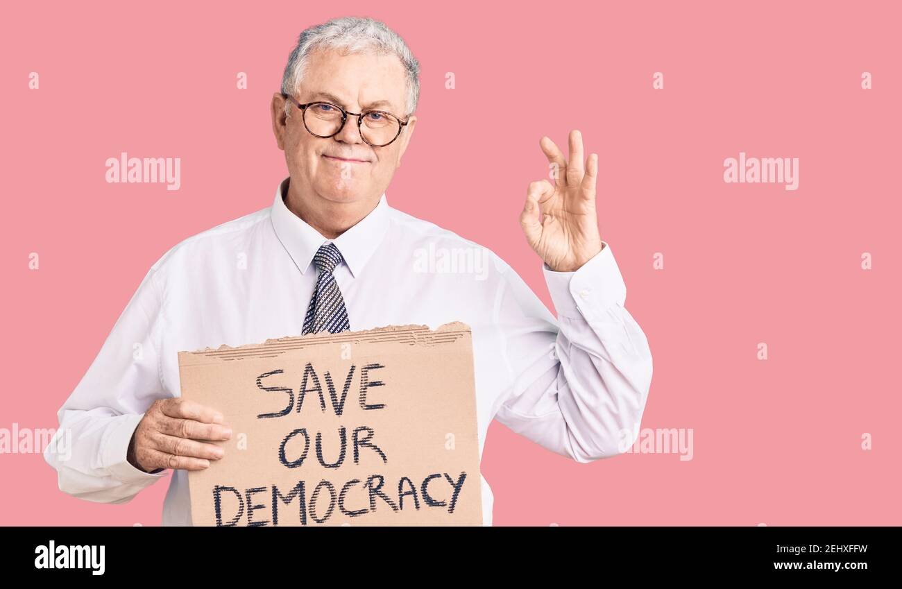 Senior grey-haired man wearing business clothes holding save our ...