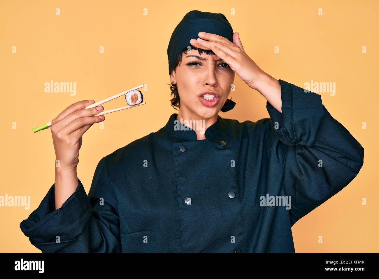 Beautiful brunettte woman chef holding sushi using chopsticks stressed ...
