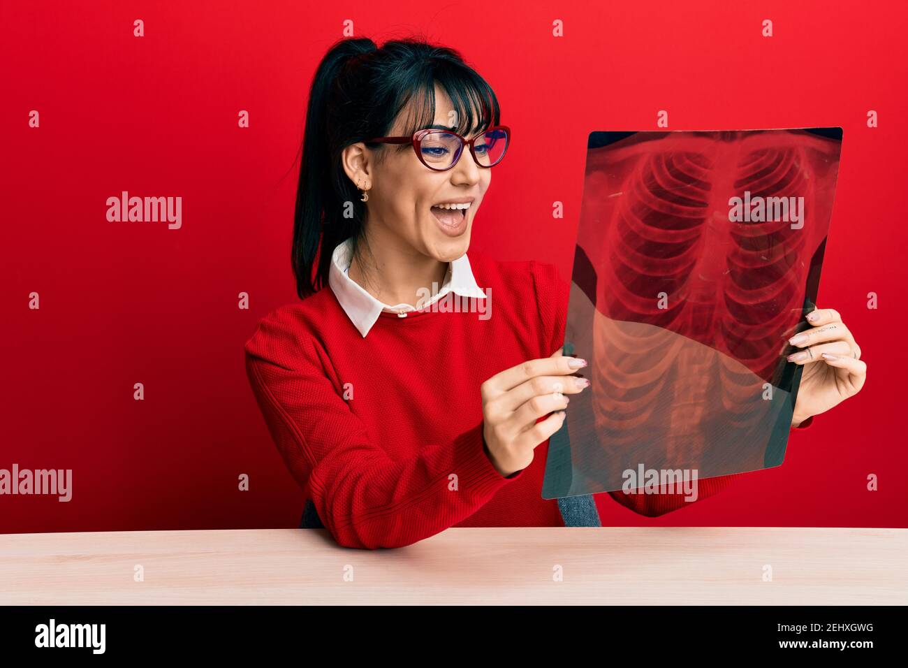 Young brunette woman with bangs holding chest radiography celebrating ...