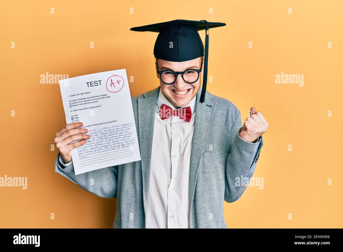 Young caucasian nerd man wearing glasses and graduation cap holding ...