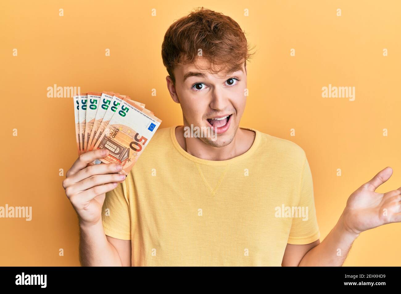 Young caucasian man holding bunch of 50 euro banknotes celebrating ...