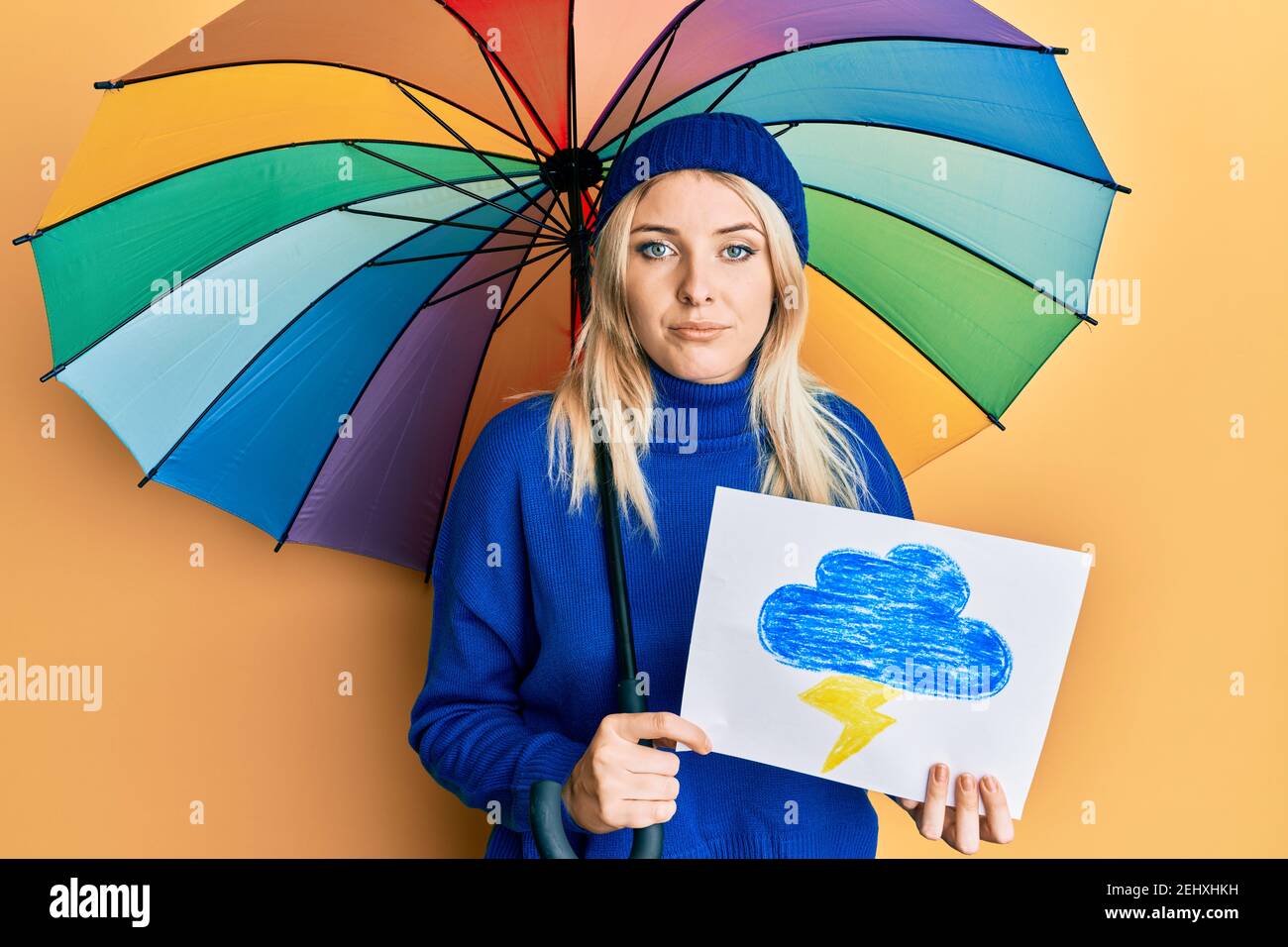 Young caucasian woman holding rain draw and umbrella depressed and ...