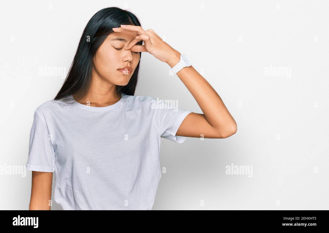 Beautiful young asian woman wearing casual white t shirt tired rubbing ...