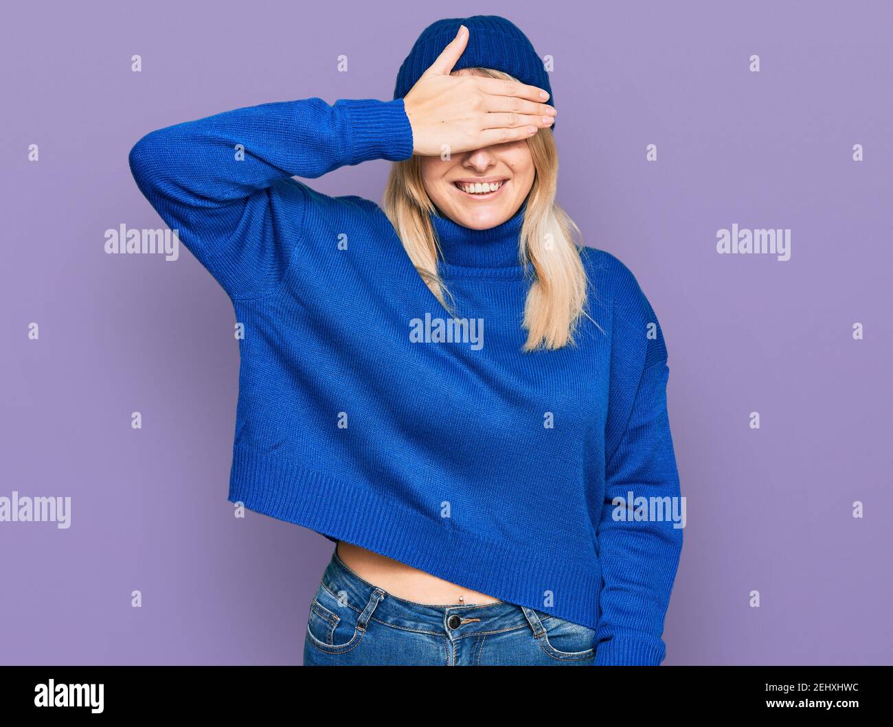 Young caucasian woman wearing wool winter sweater and cap smiling and ...