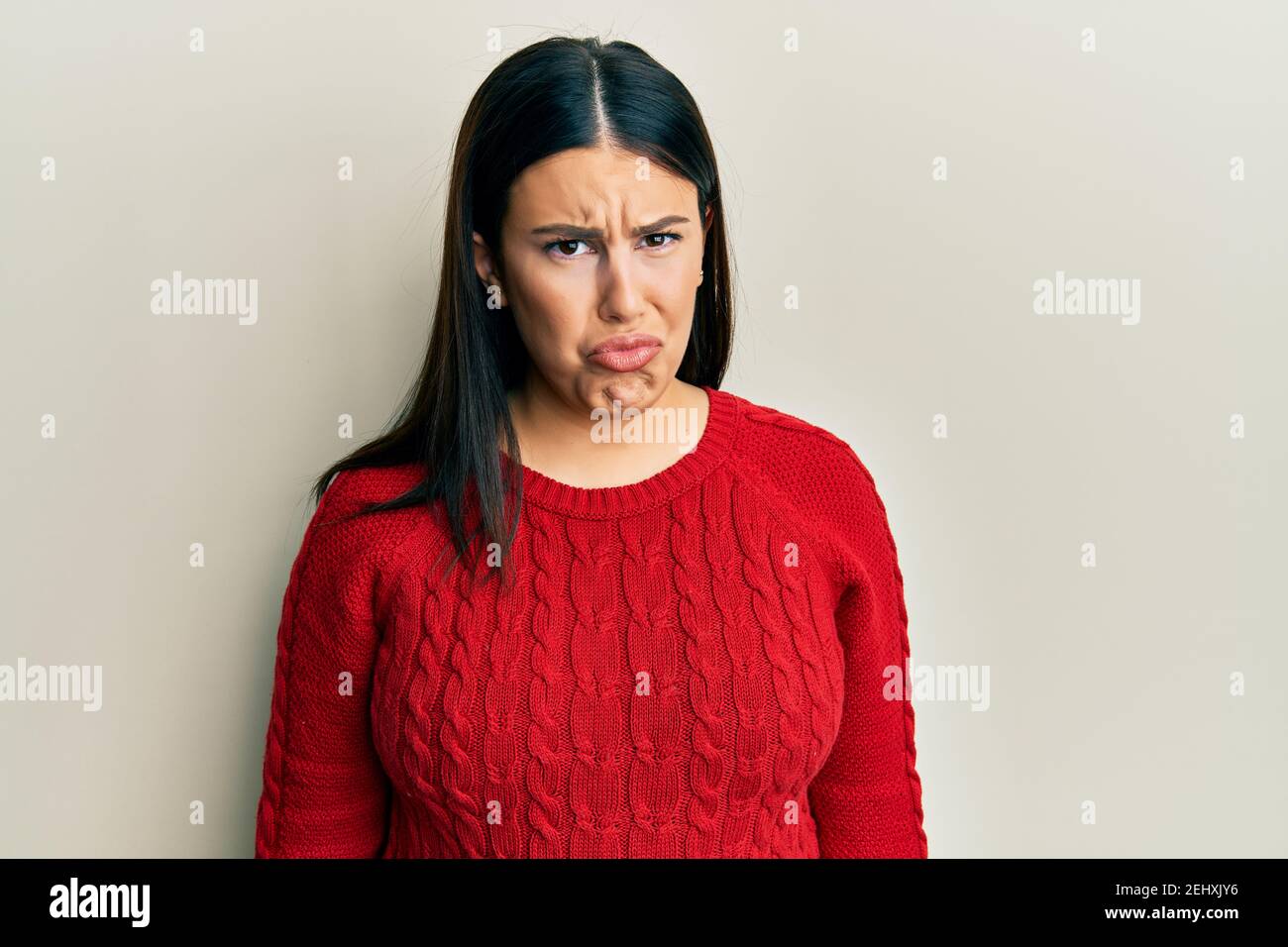 Beautiful brunette woman wearing wool winter sweater depressed and ...