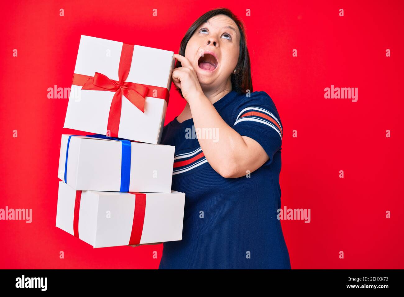 Brunette woman with down syndrome holding gifts angry and mad screaming ...