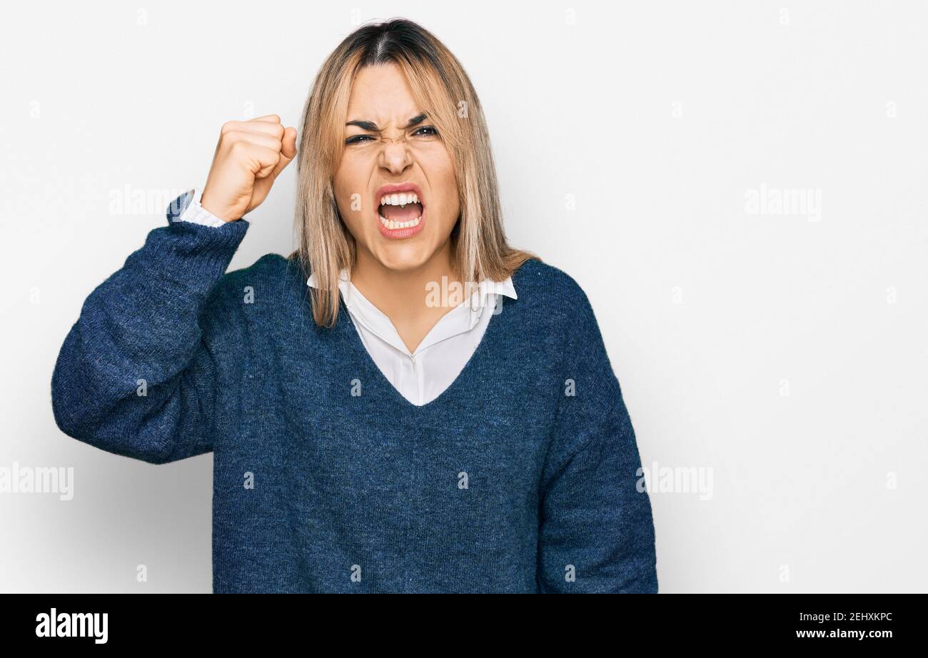 Young caucasian woman wearing casual clothes angry and mad raising fist ...