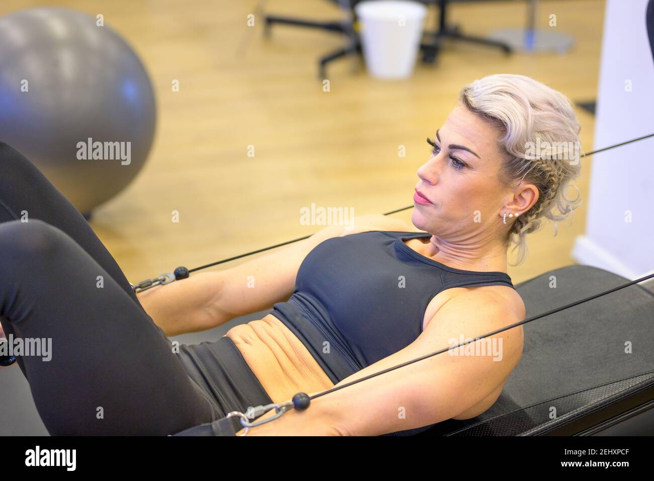 Fit woman doing resistance training to strengthen her muscles in ...