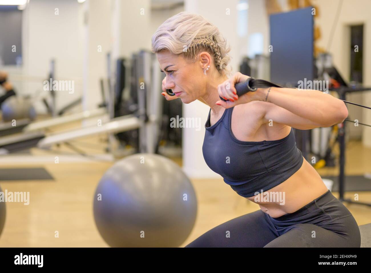Attractive fit healthy athletic middle-aged woman working out in a gym ...