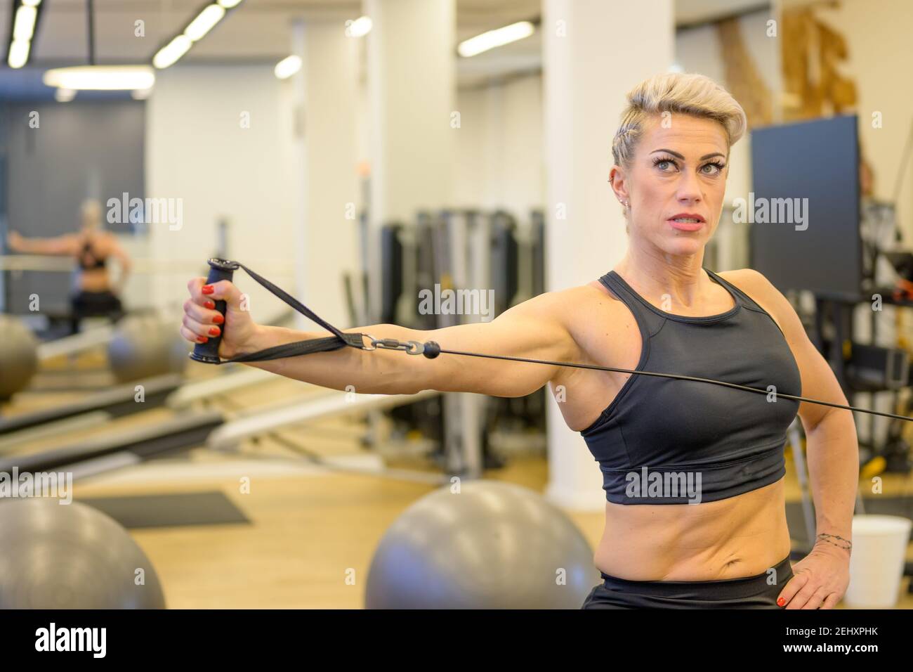 Sporty middle-aged woman working out with resistor stretch bands in a ...