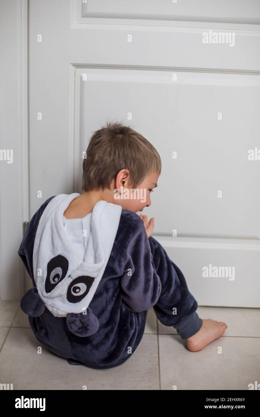 the upset kid is sitting on the floor in a closed position Stock Photo ...
