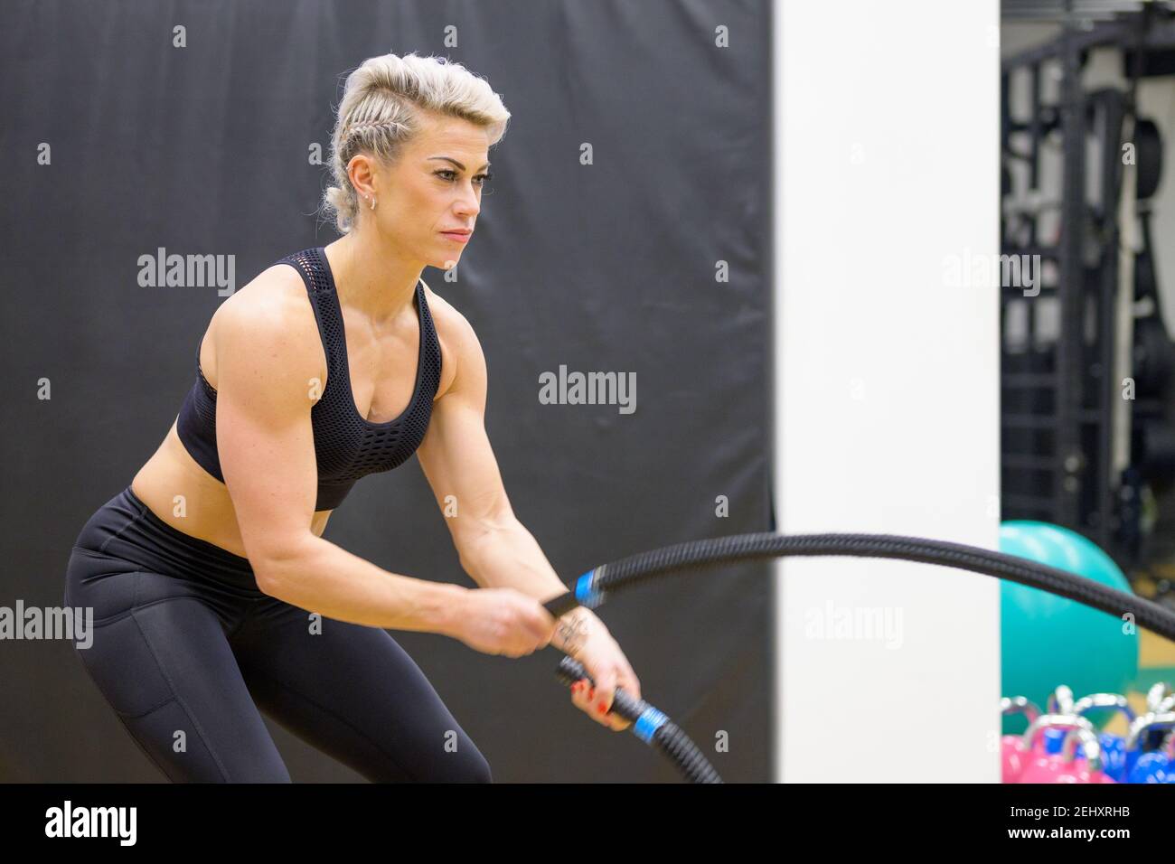 Muscular sporty middle-aged woman working out in a gym in a close up ...