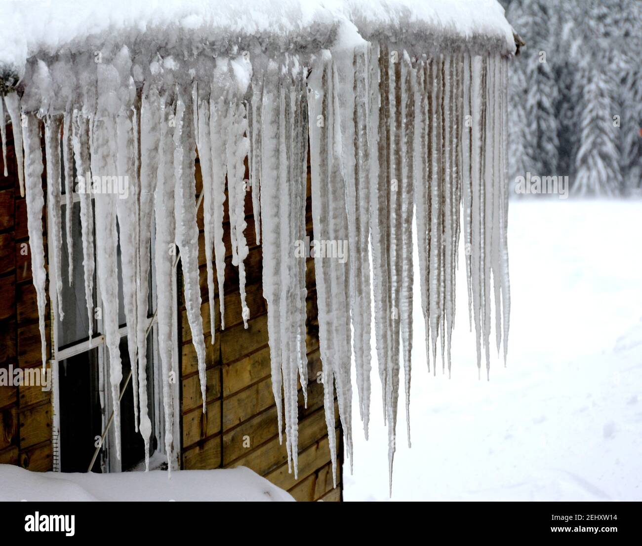 Chilling view of icicles hanging on a roof Stock Photo - Alamy
