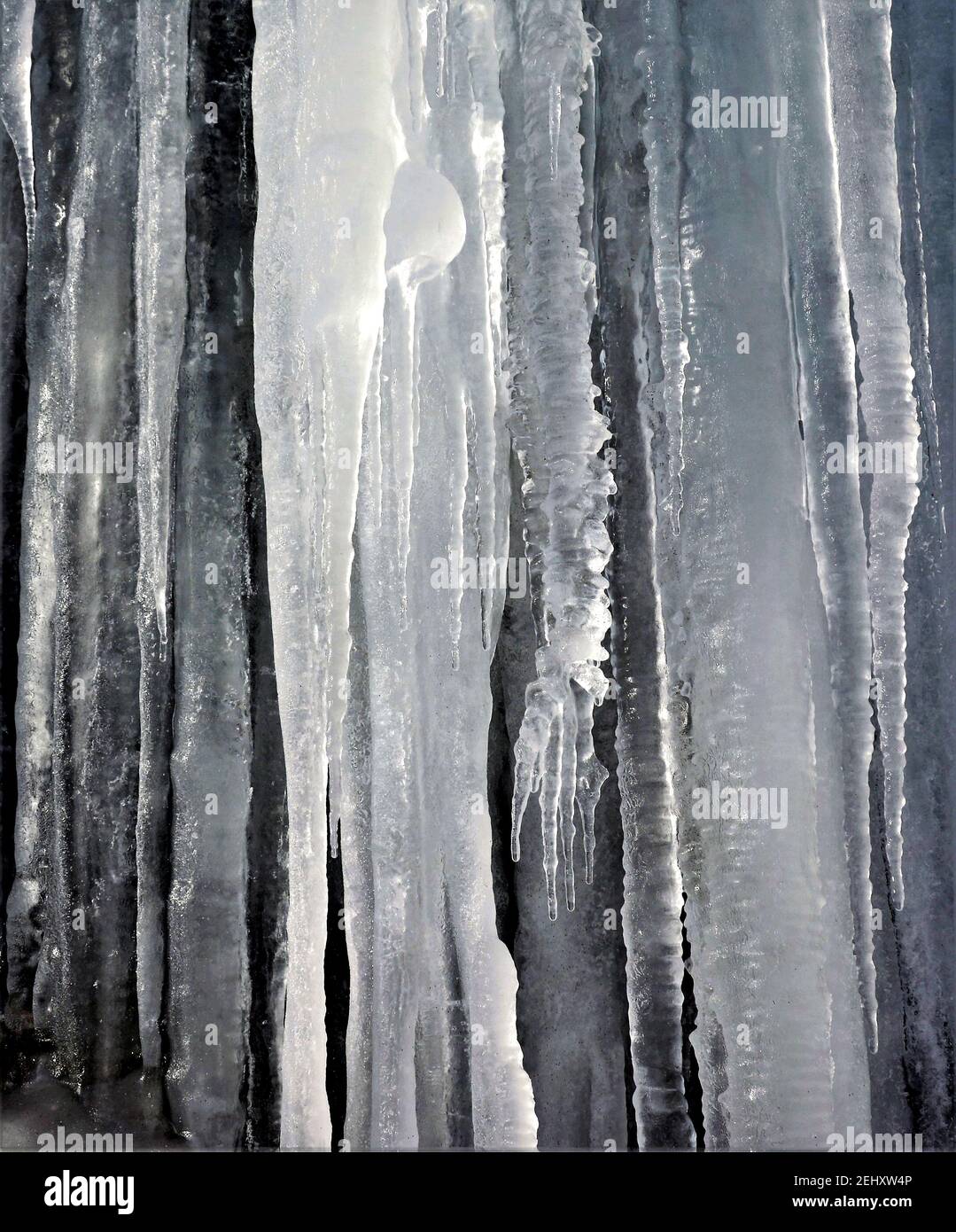 Vertical shot of long icicles hanging on a cliff Stock Photo - Alamy