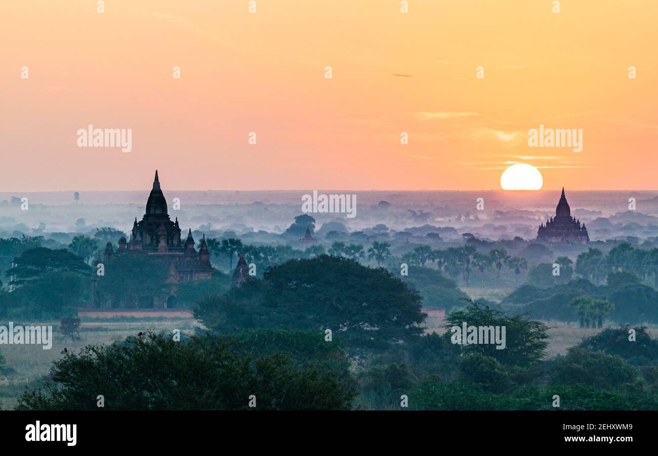 Misty, colorful sunrise over the plains of Bagan archaeological site in ...