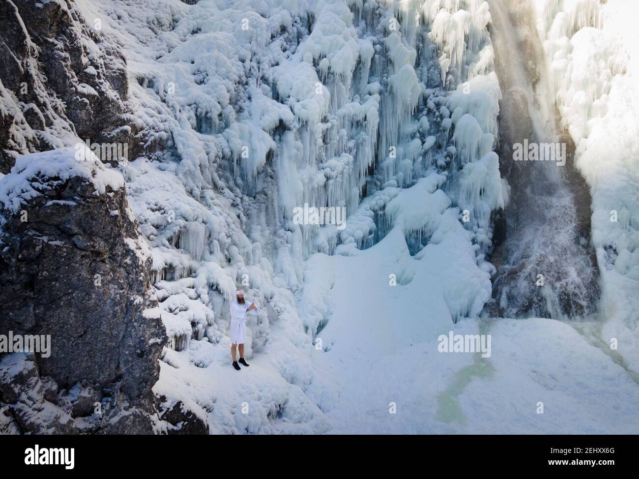 European man in traditional Japanese shugendo outfit meditating next to ...