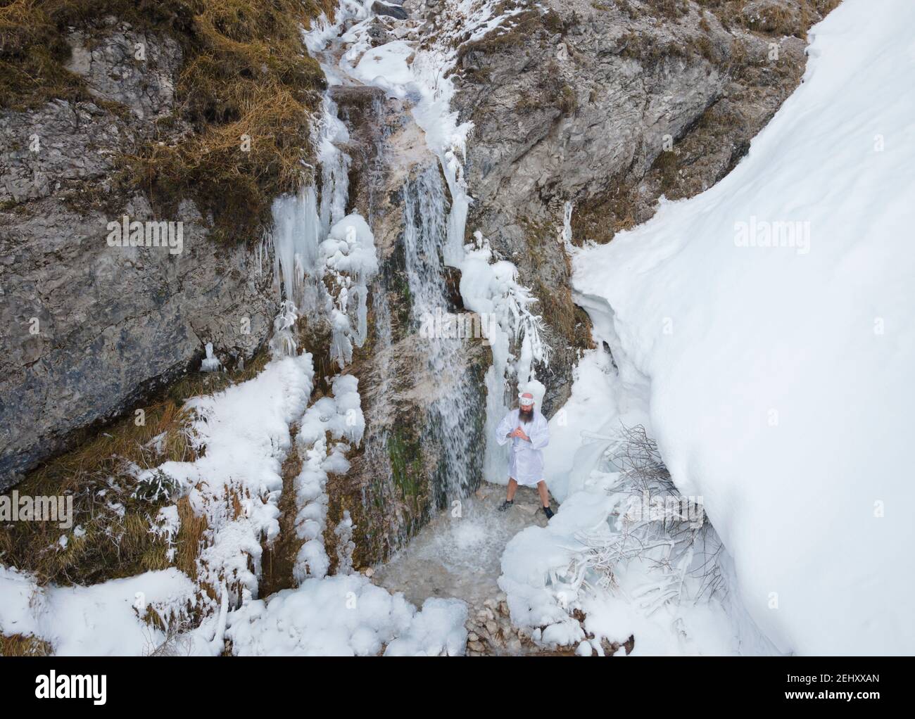 European man in traditional Japanese shugendo outfit meditating next to ...