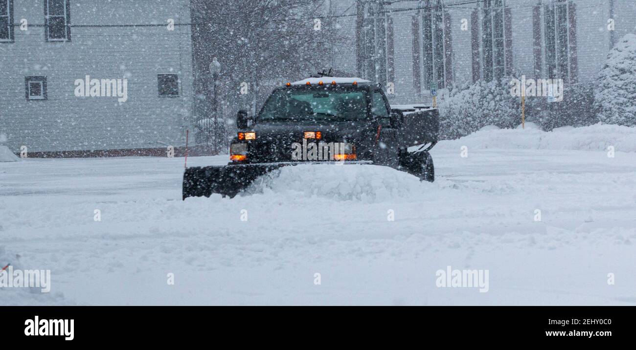 A private contracter is plowing the snow in a parking lot for the local ...