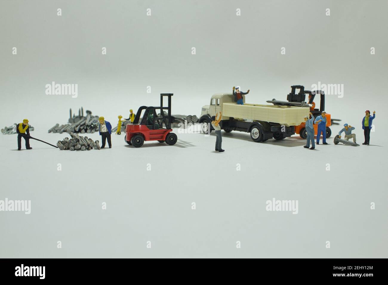Closeup of miniature figures of construction workers trying to load a ...