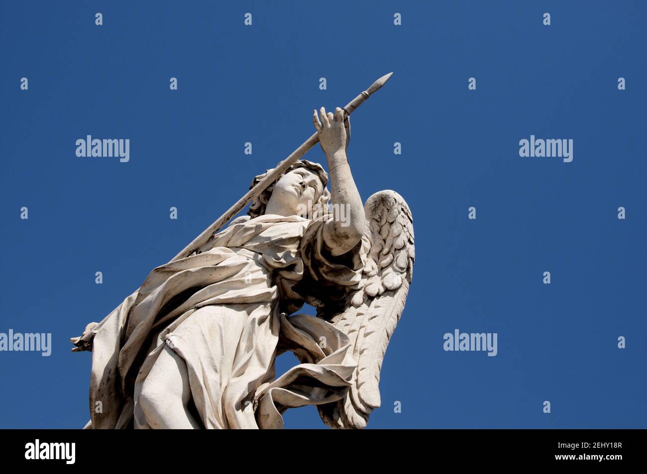 Low angle shot of a statue on St. Angelo Bridge under the blue sky, in ...