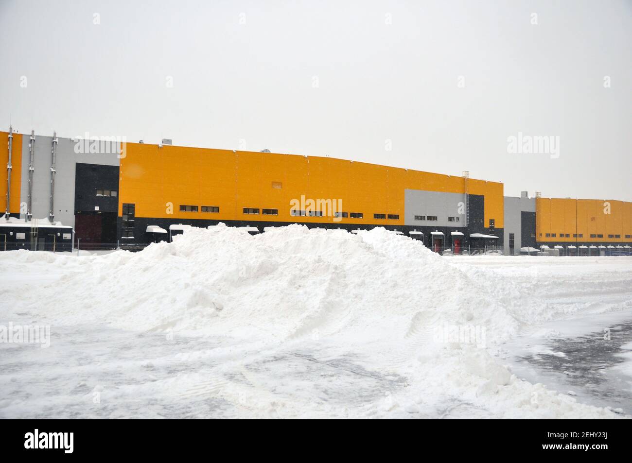 a mountain of snow on the territory of a modern logistics complex Stock ...