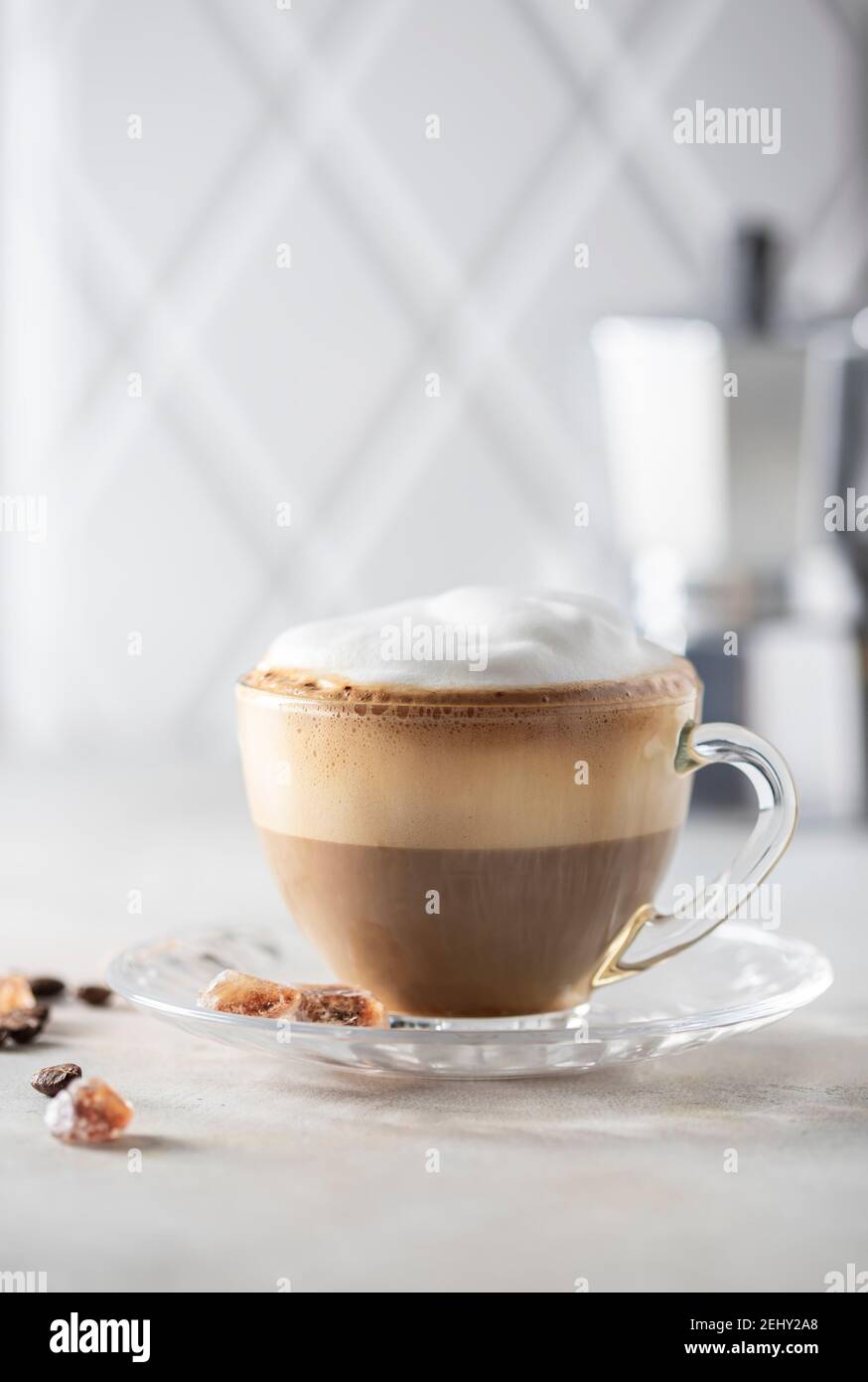 Transparent cup of cappuccino with foam on a white background. Hot ...