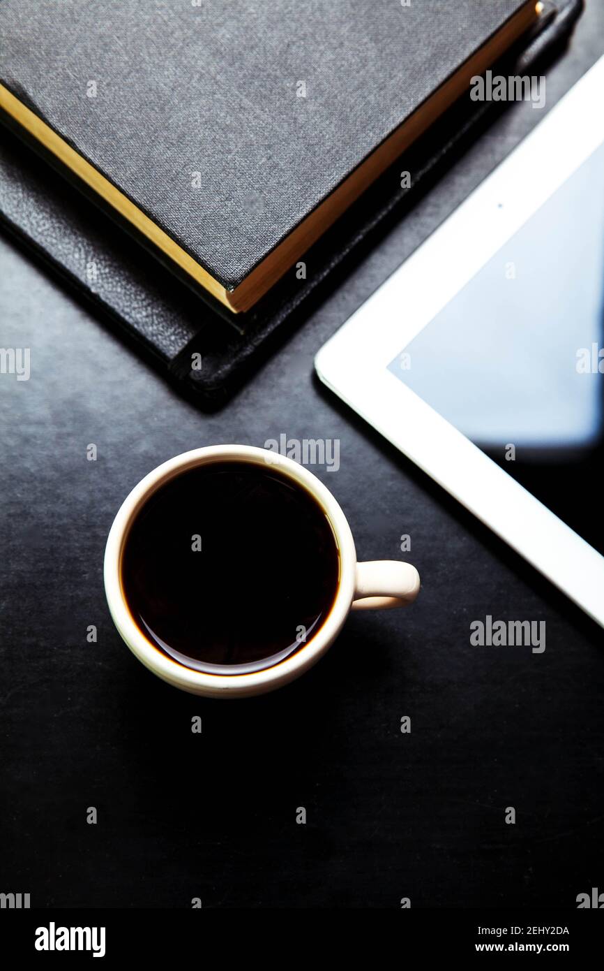 empty tablet pc and a coffee and notebook with pen on the office desk ...