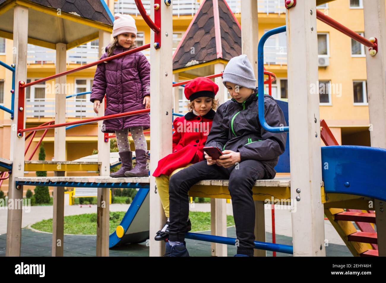 Neighbours and playmate kids with smartphone on a playgound Stock Photo ...