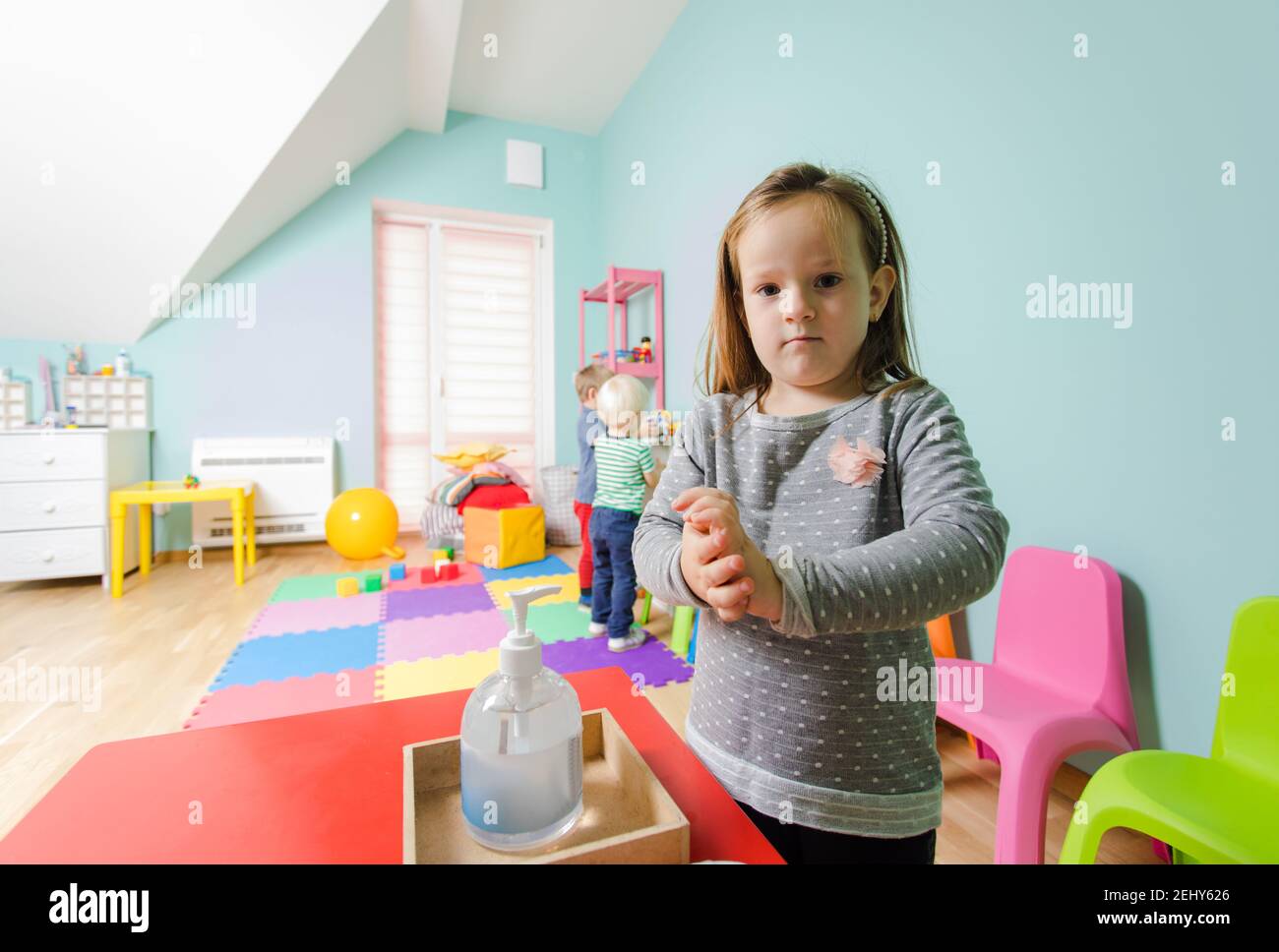 the little girl kills germs to use antibacterial gel Stock Photo - Alamy
