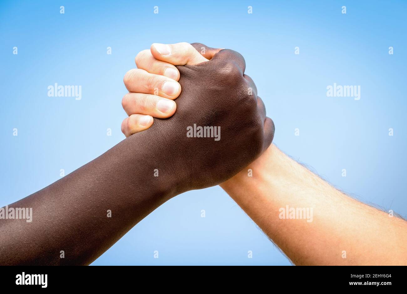 Black and white human hands in a modern handshake to show each other ...