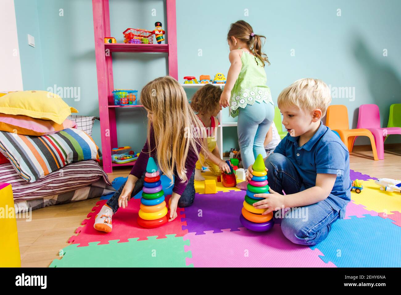 Kids playing together on a colorful mats Stock Photo - Alamy