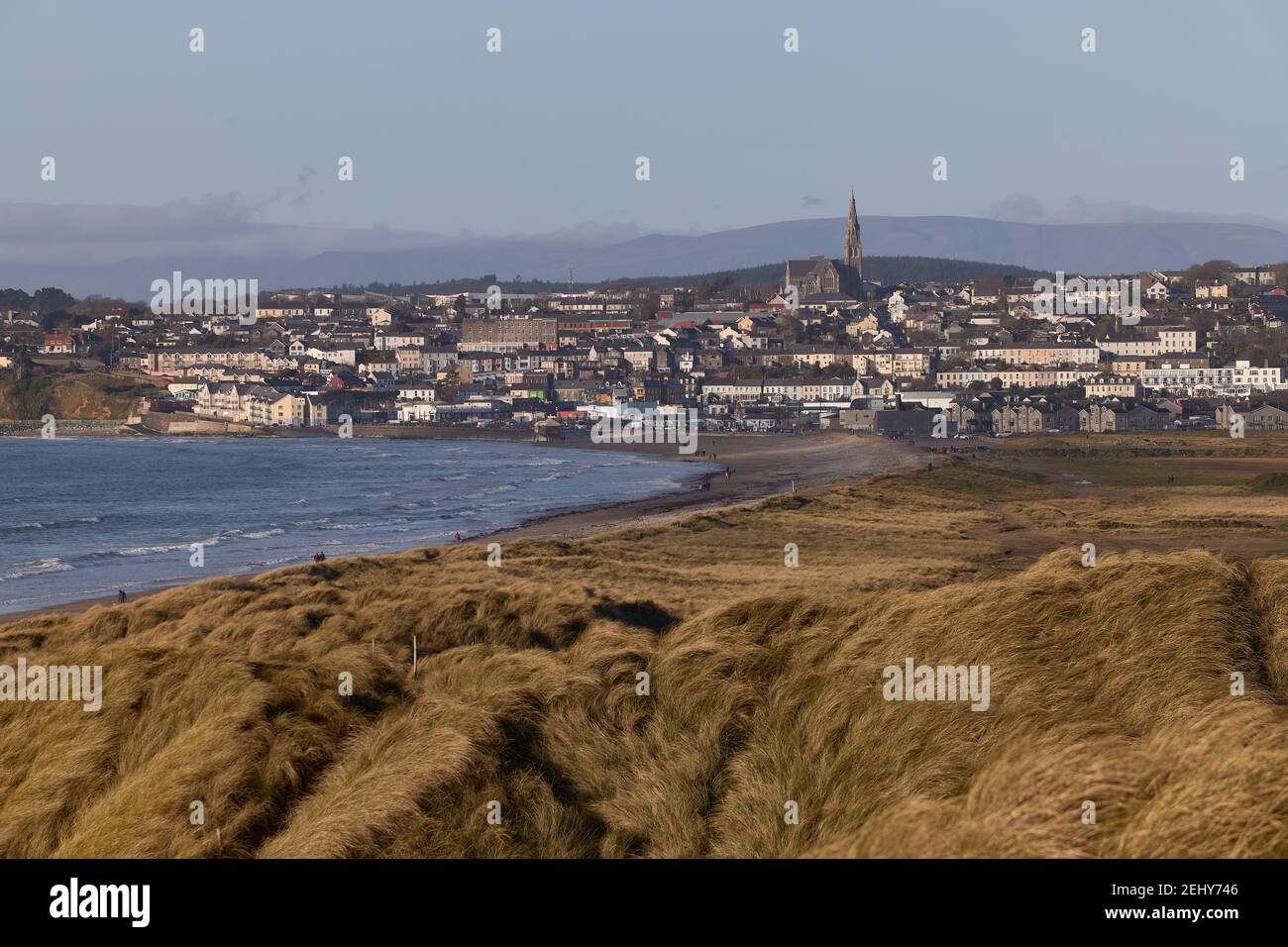 Irish beach with city in the background with Catholic church on top of ...