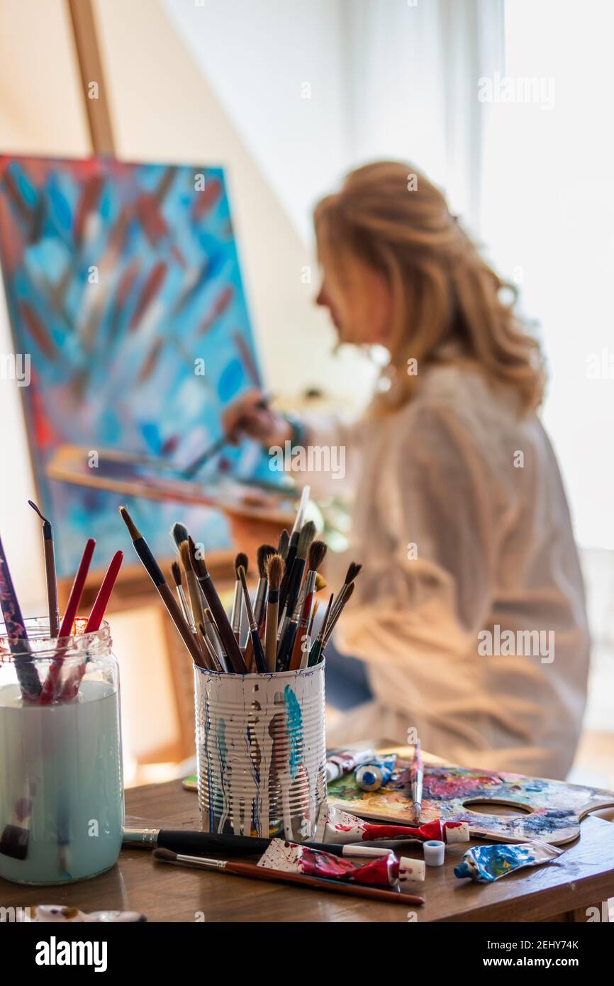 Art painter working on her abstract paintings at workshop. Selective ...