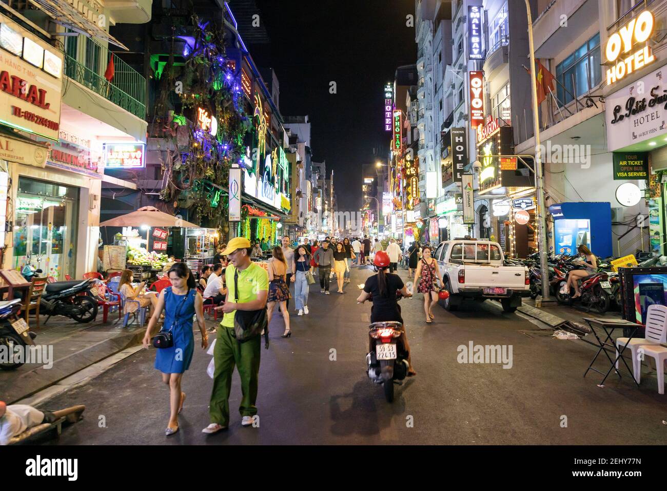 People walking down the colourful and busy Bui Vien street, famous for ...