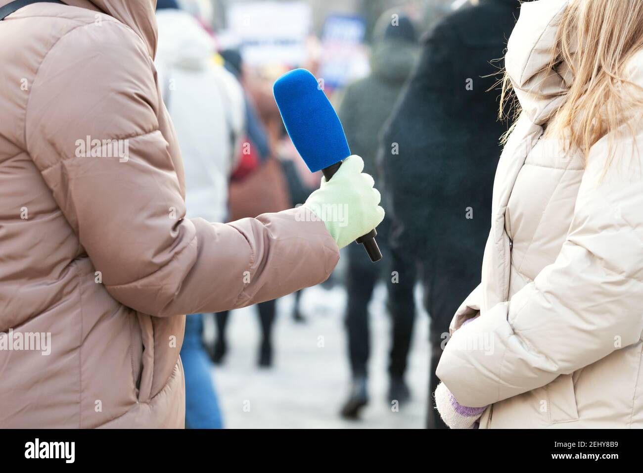 Press interview during winter at street, reporter holding microphone ...