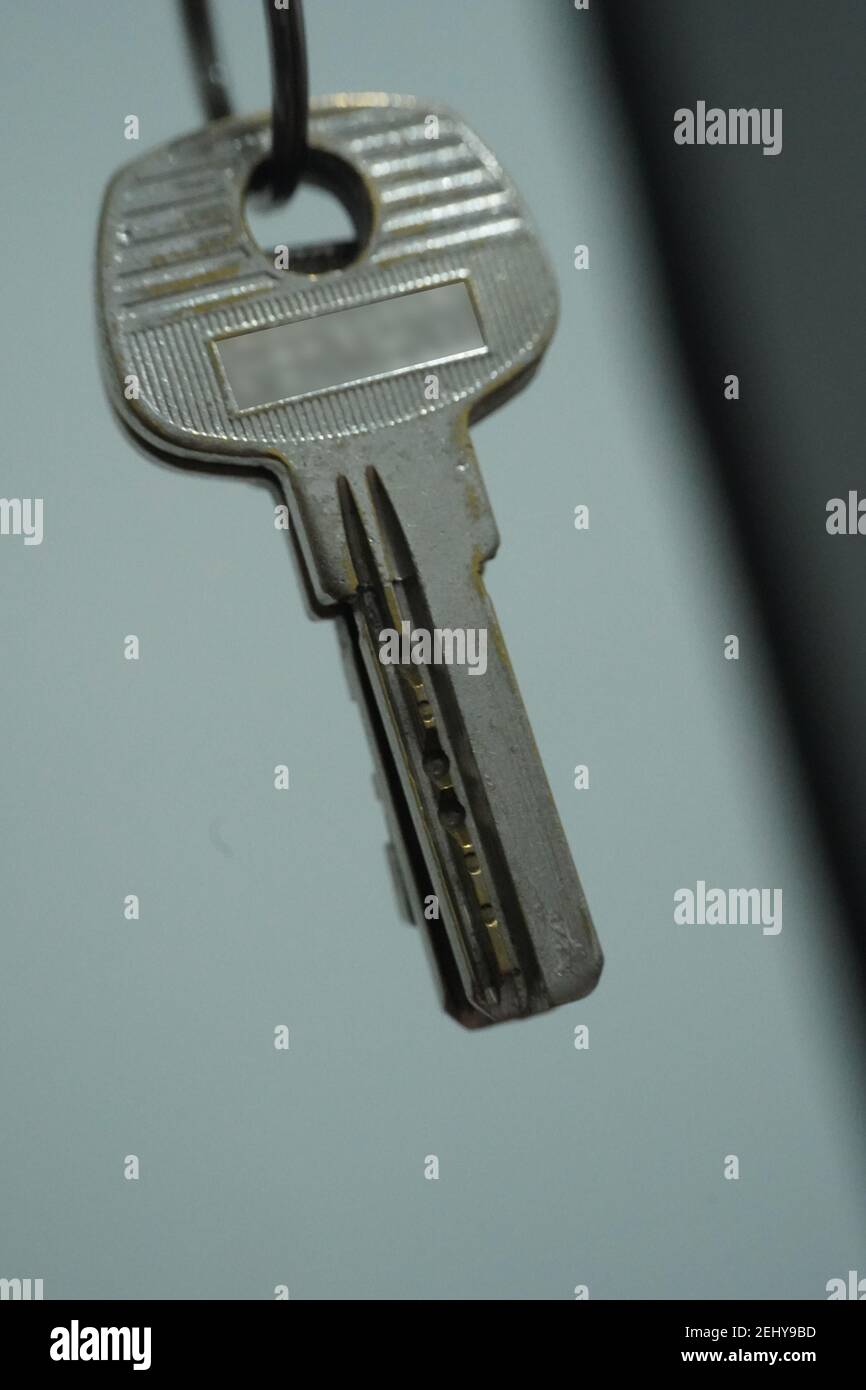 Vertical shot of keys on a blurred back Stock Photo - Alamy