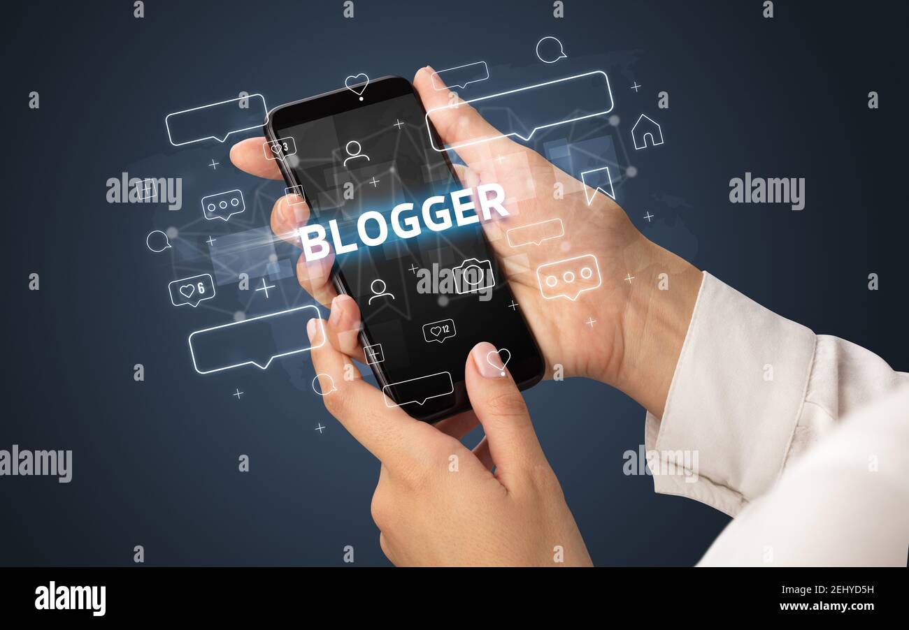 Female hand typing on smartphone with BLOGGER inscription, social media ...