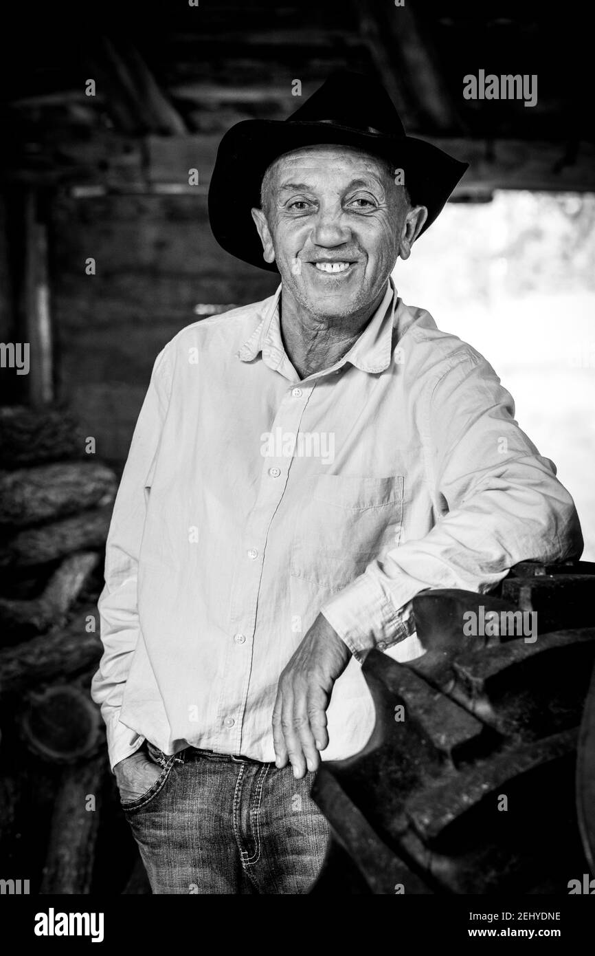 a black and with portrait of a smiling country man with a cowboy hat ...