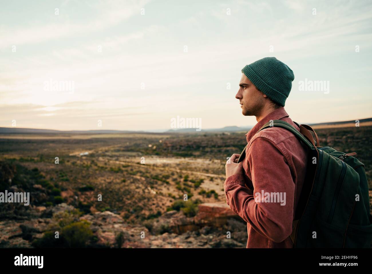 Caucasian male free spirit hiking in wilderness with backpack embracing ...